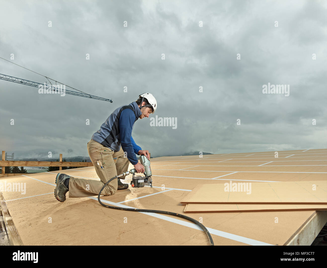 Austria, construction worker fixing medium-density fibreboard Stock ...