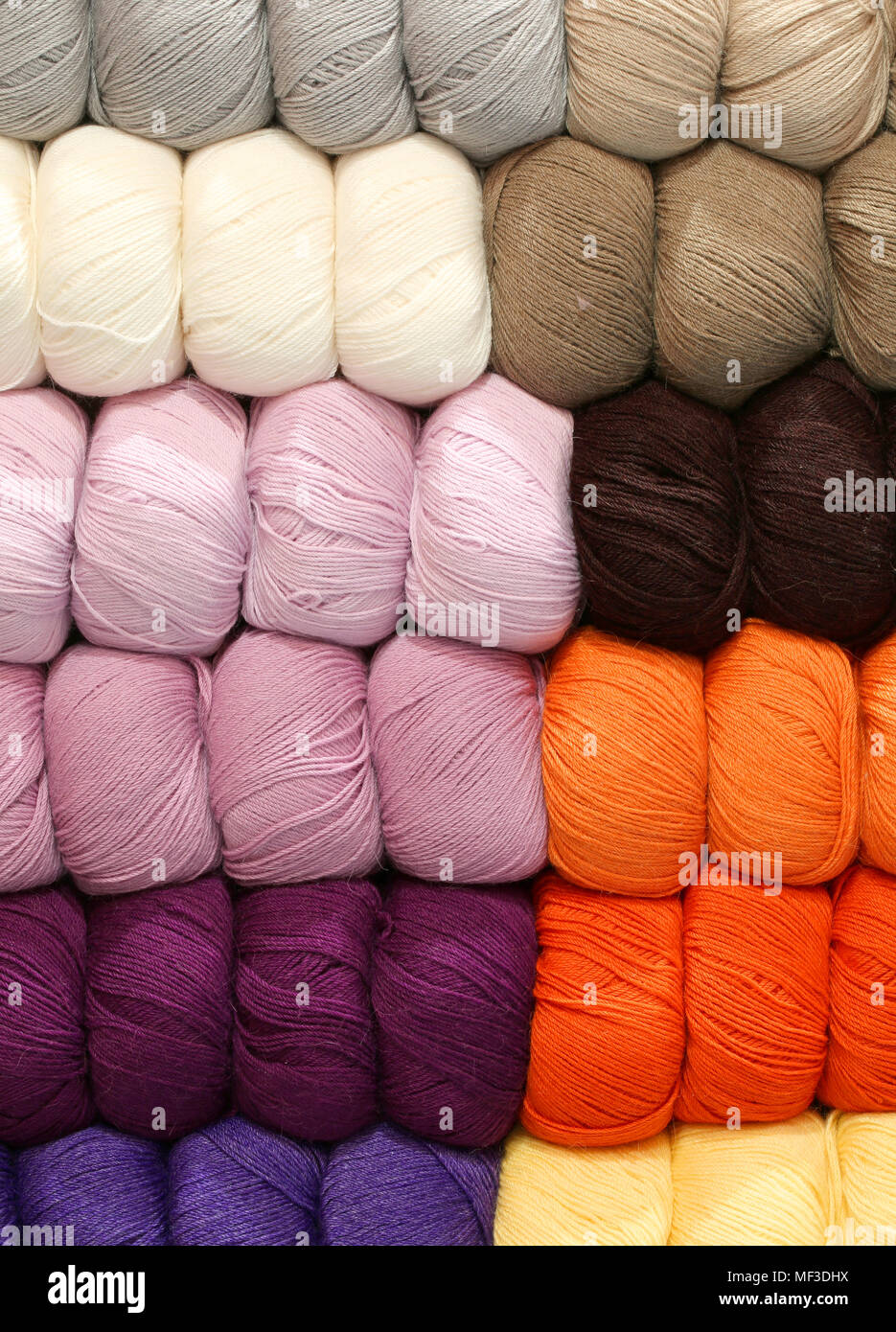 balls of wool of many colors lined up and arranged neatly in a large ...