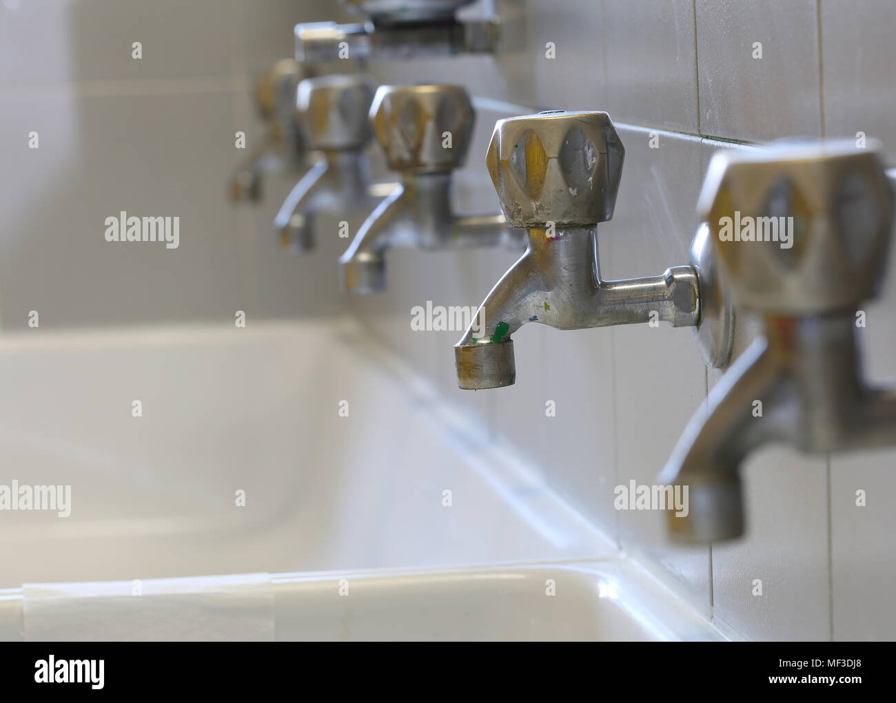 Closed faucets in a row are turned on a large marble sink Stock Photo ...
