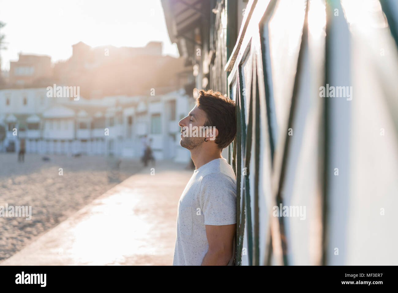 Young man relaxing on the beach at sunset Stock Photo - Alamy