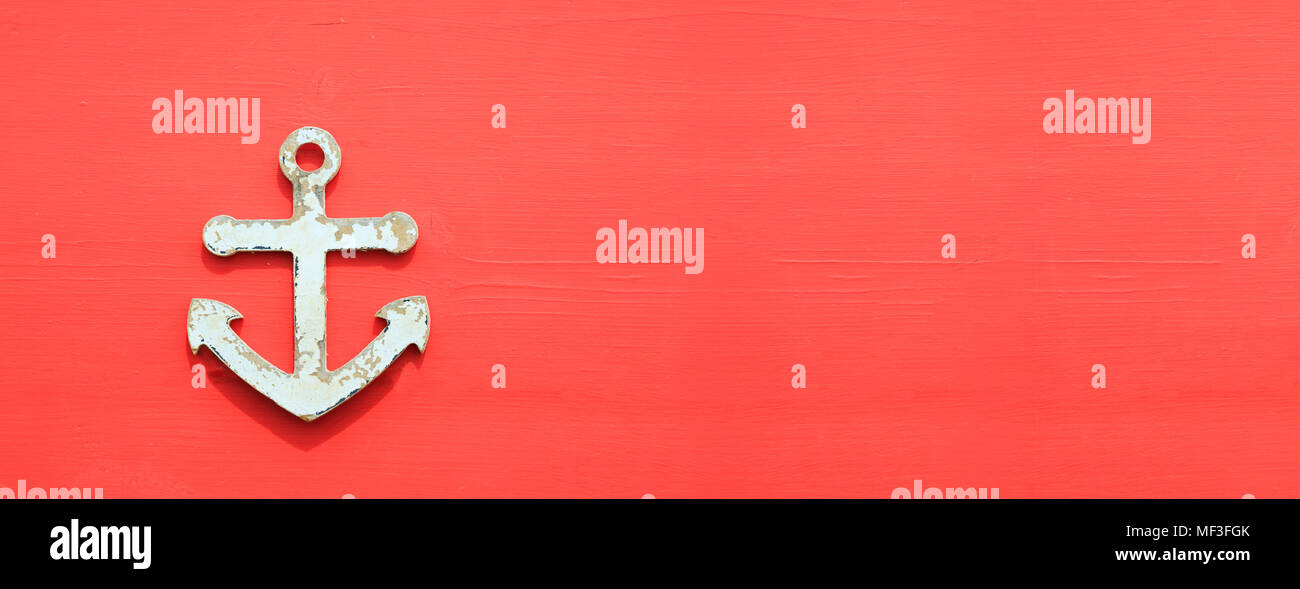 Anchor symbol on aged surface. Peeled sign, red board background ...