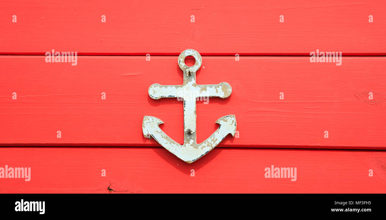 Anchor symbol on aged surface. Peeled sign, red blank board background ...