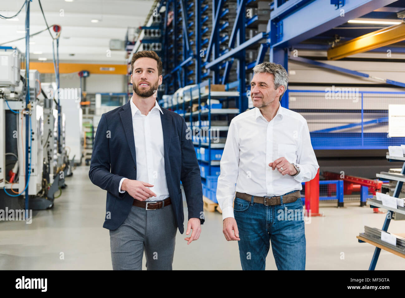 Smiling managers in a production hall Stock Photo - Alamy