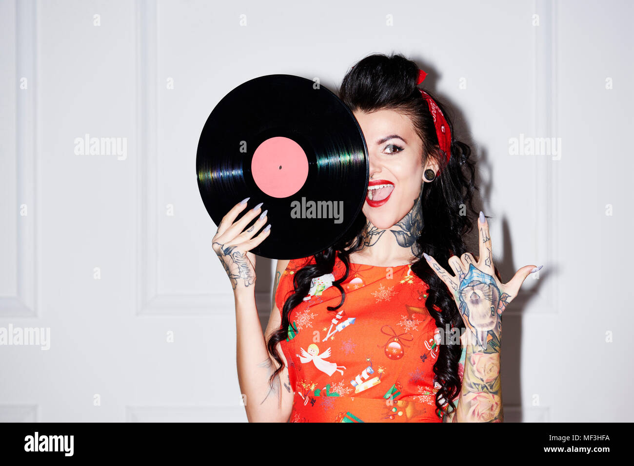 Portrait of tattooed woman with record showing Rock And Roll Sign Stock ...
