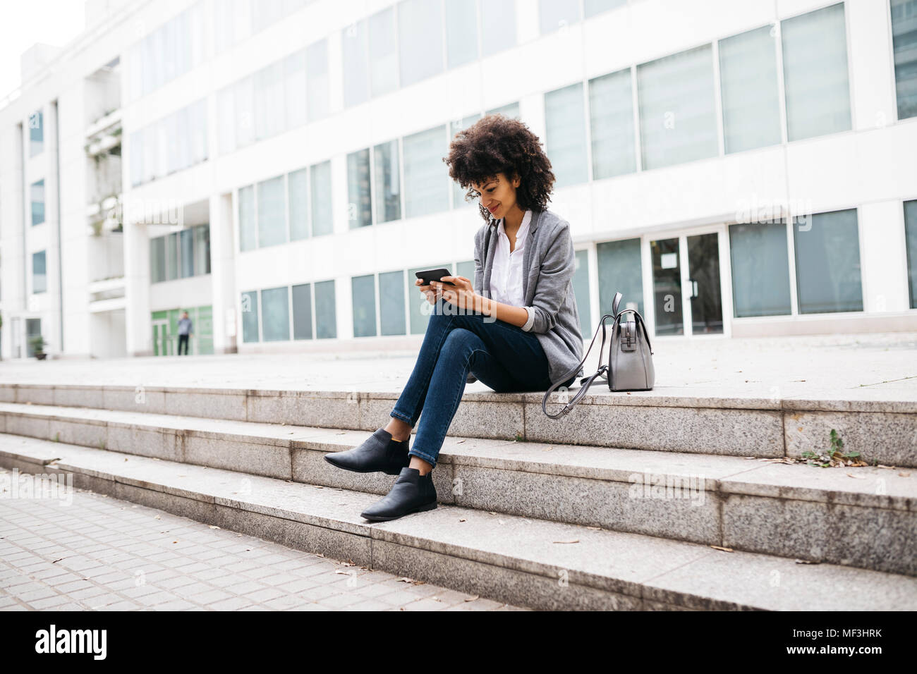 Woman sitting on stairs cell hi-res stock photography and images - Alamy
