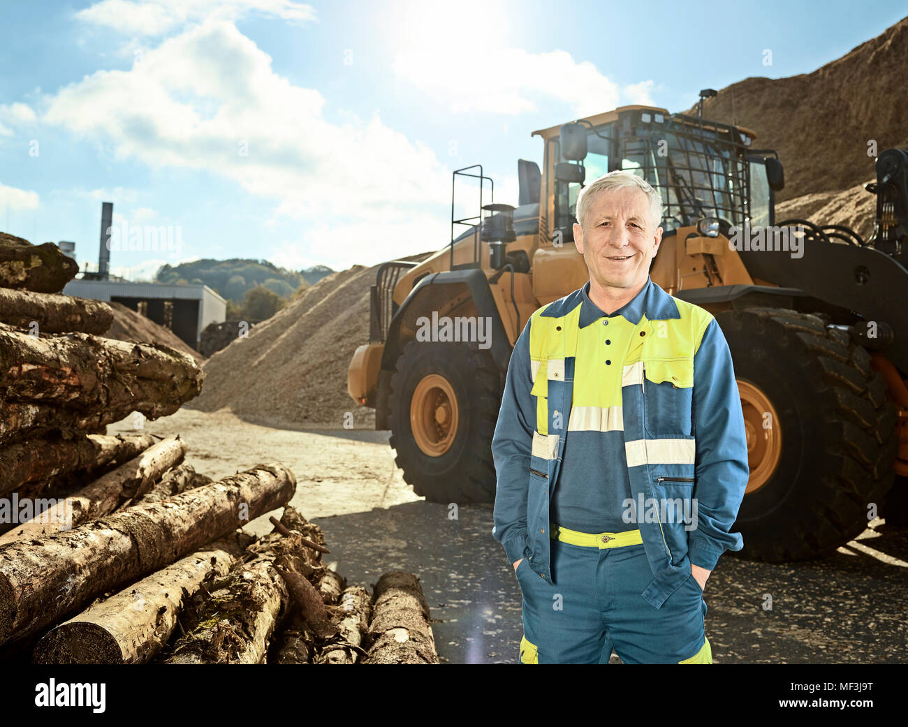 Woodworking, smiling worker standing in front of wheel loader Stock ...