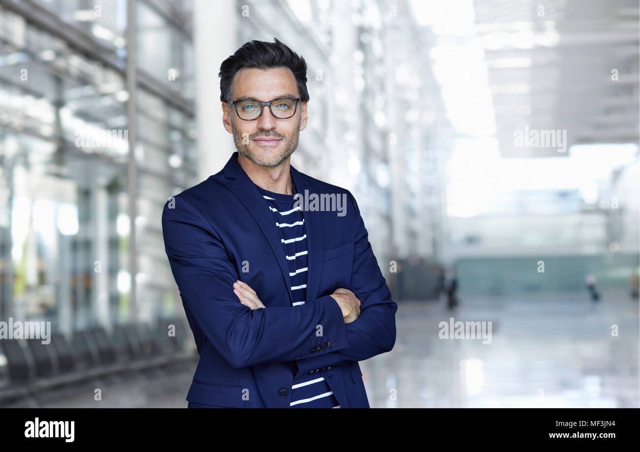 Portrait Of Stylish Businessman With Stubble Wearing Blue Suit And