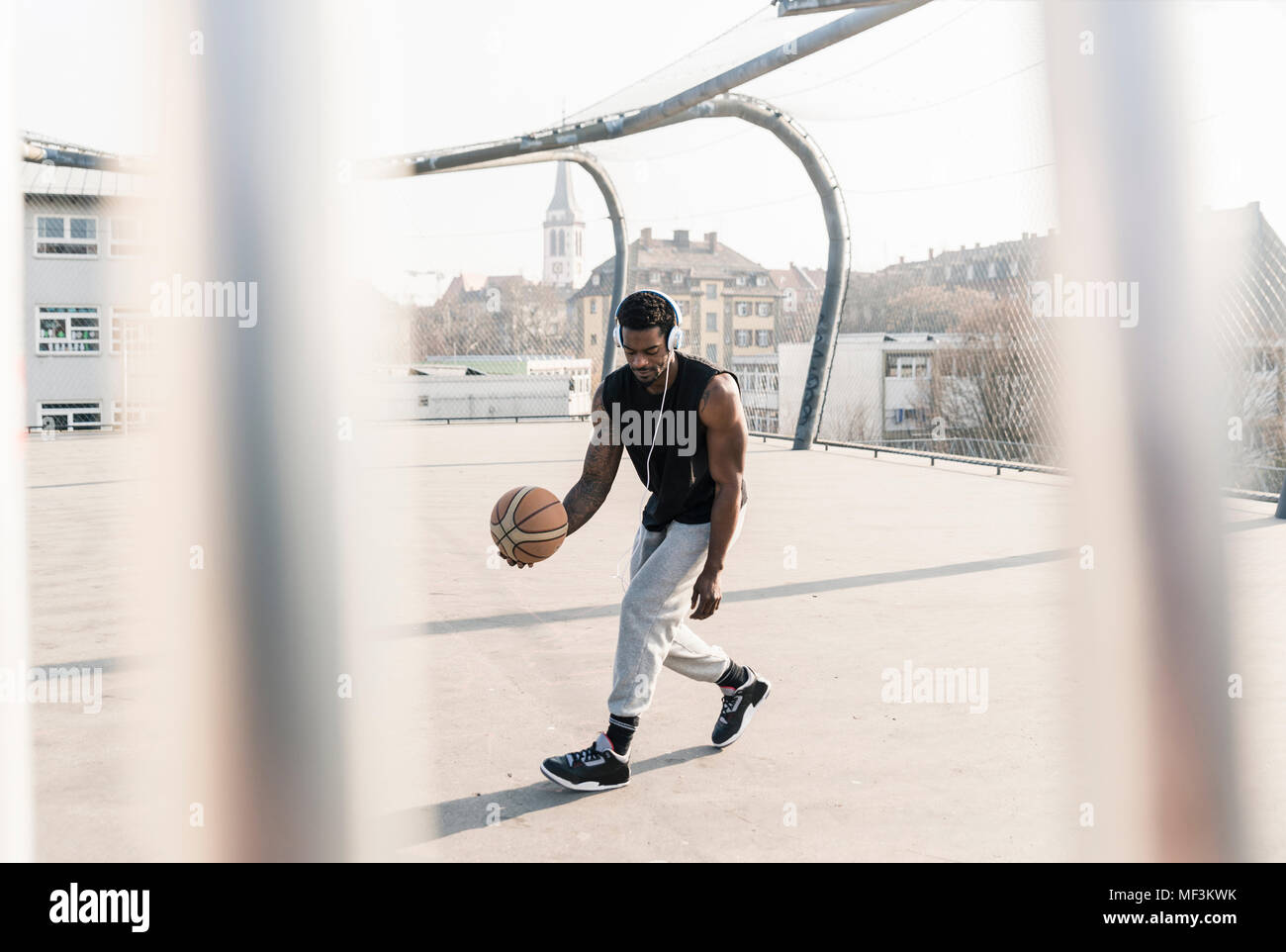 Basketball player with headphones in action on court Stock Photo - Alamy