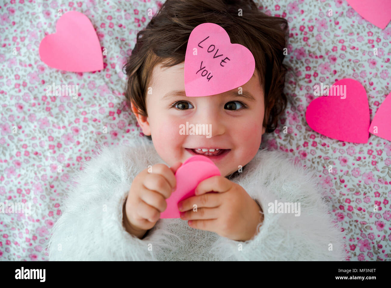 Portrait of baby girl with pink heart-shaped post it stickers Stock ...