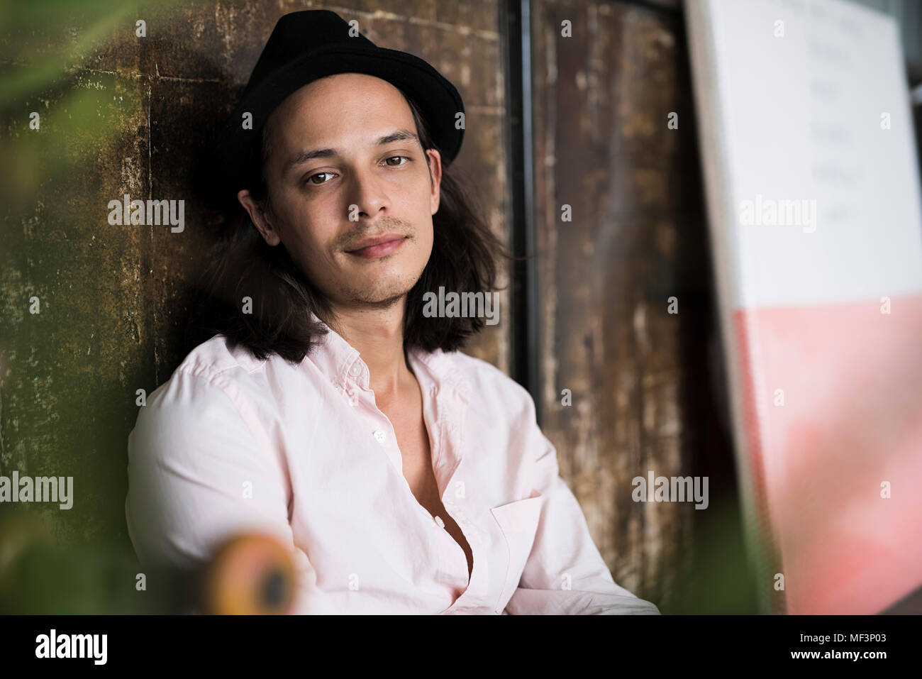 Portrait of artist leaning against wall in his loft studio Stock Photo ...