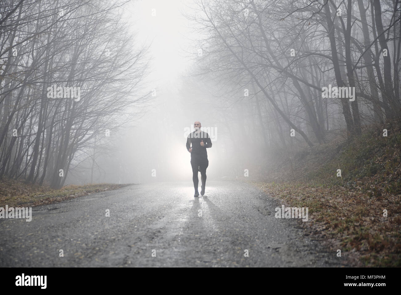 one runner jogging, outdoors mist fog, mysterious forest Stock Photo ...