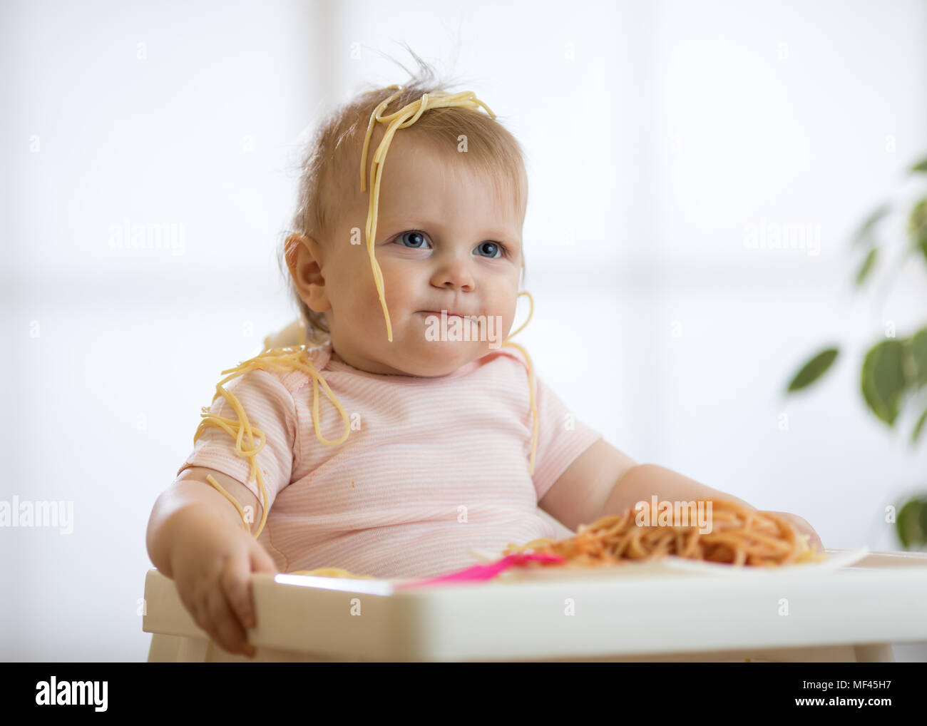baby girl eating messy spaghetti Stock Photo - Alamy
