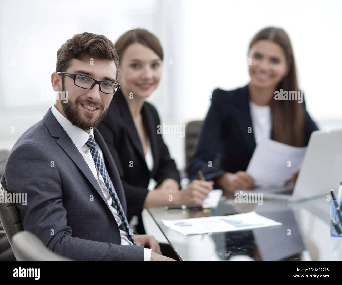 closeup.confident businessman sitting behind a Desk Stock Photo - Alamy