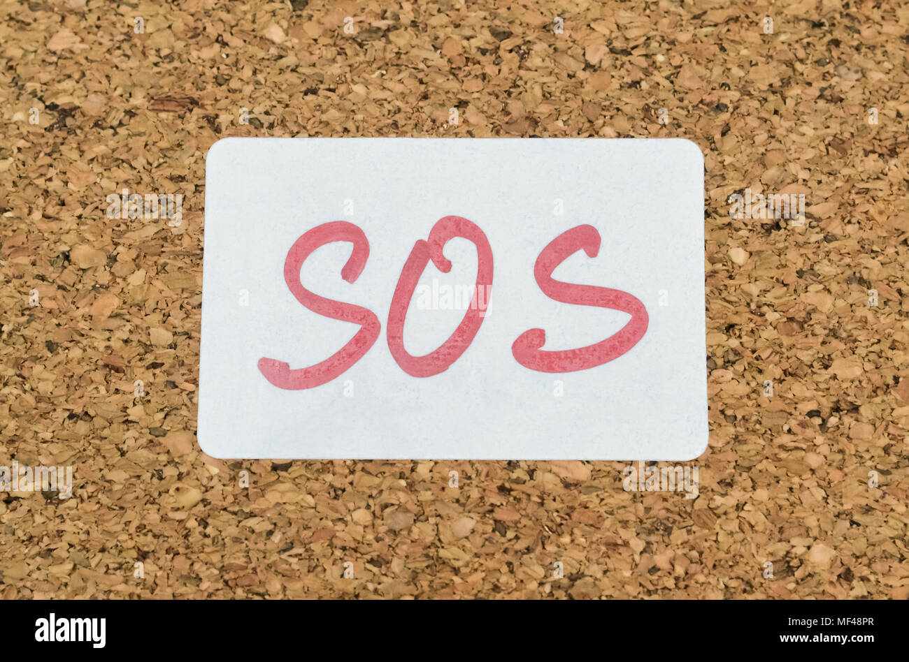Word SOS handwritten on a sticker pinned on a cork board Stock Photo ...
