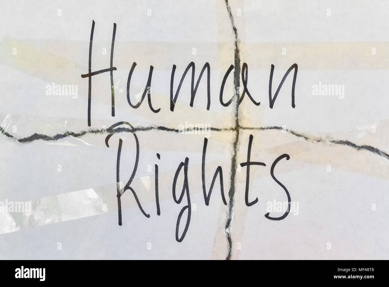 Text Human Rights written on torn paper and glued with scotch tape ...