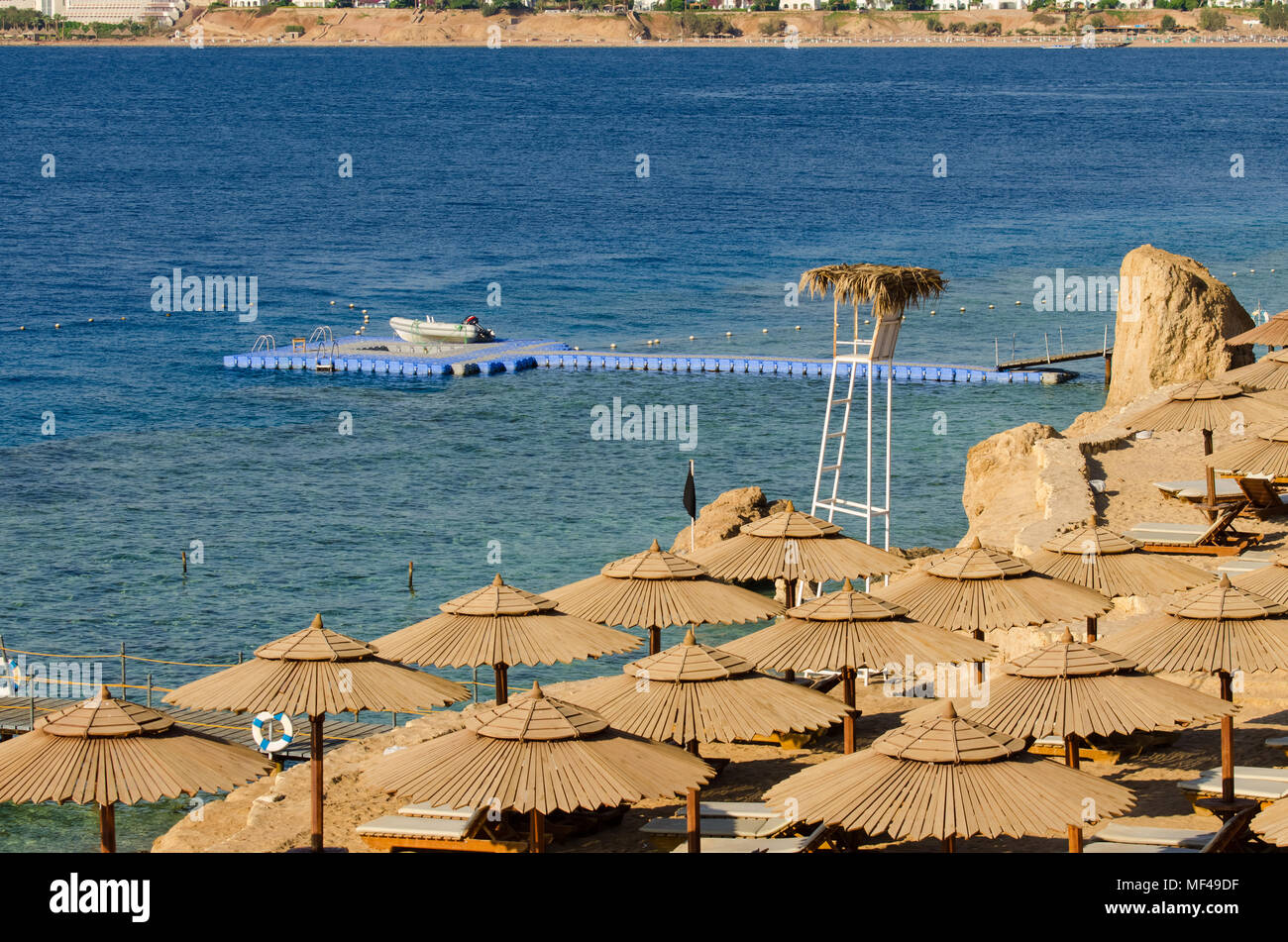 On the seashore you can see a pantone with a boat and sun umbrellas ...