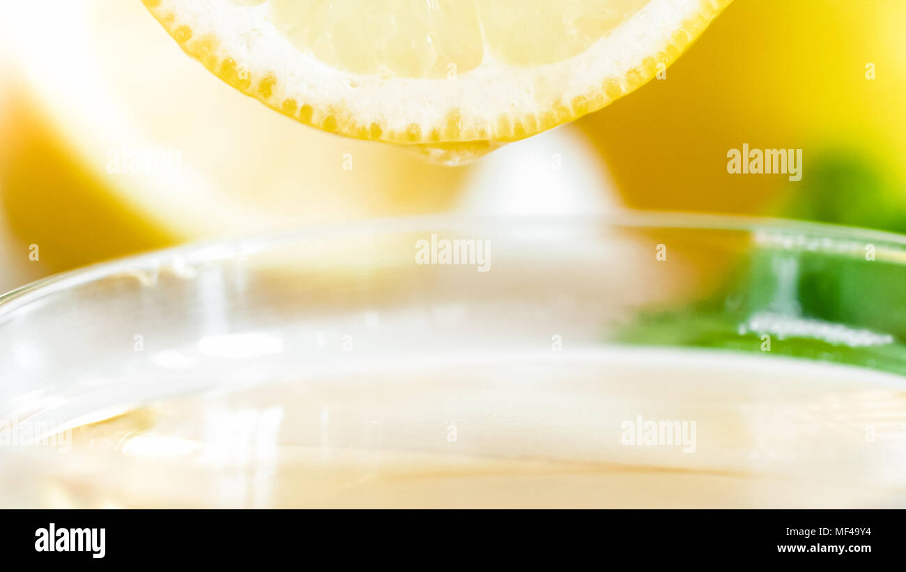 Closeup image of side of fresh lemon slice and transparent tea cup ...