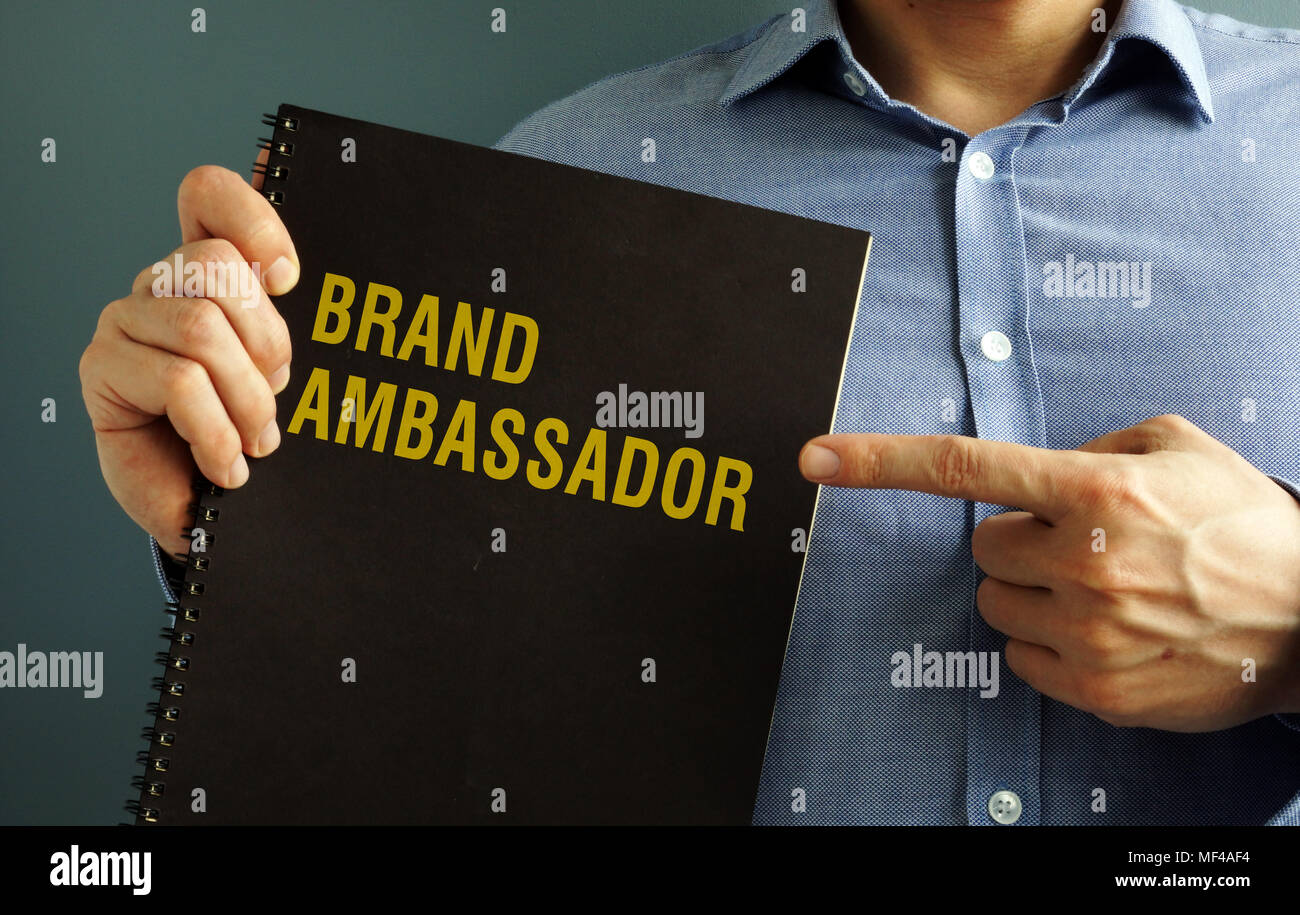 Man is holding book with title Brand Ambassador Stock Photo - Alamy