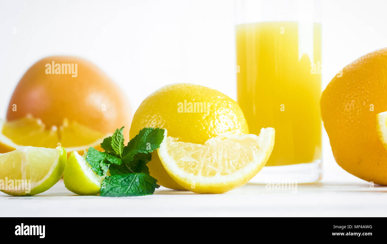 Closeup image of lemons and oranges with glass of fresh orange juice on ...