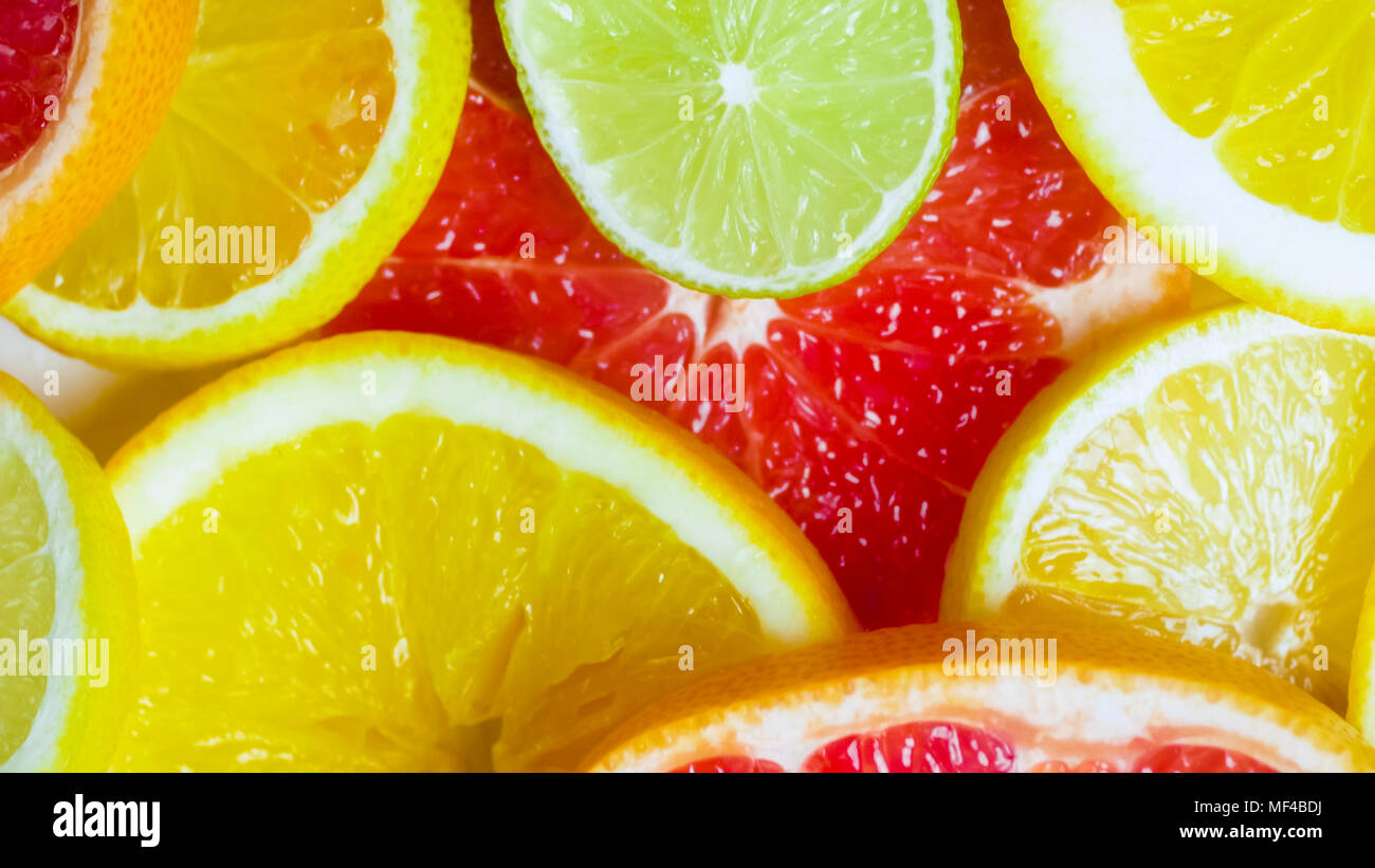 Closeup background of freshly cut oranges, grapefruits, limes and ...