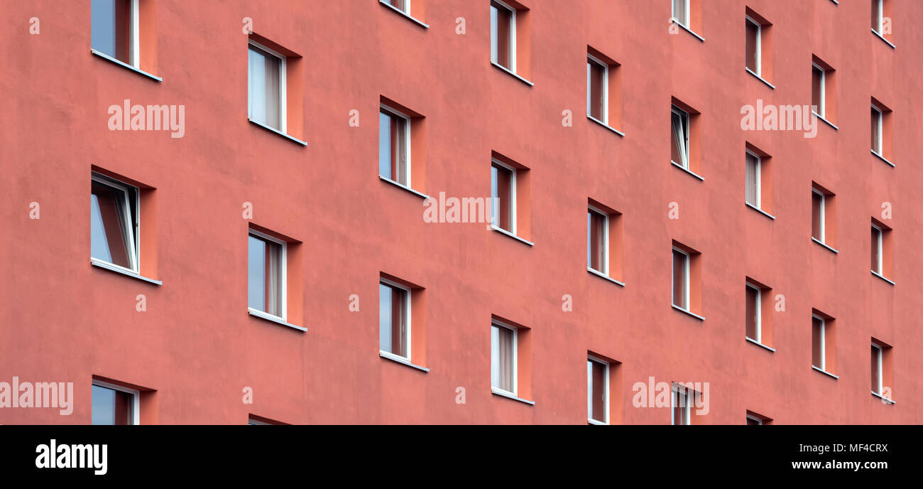 red color building wall with regular windows pattern Stock Photo - Alamy