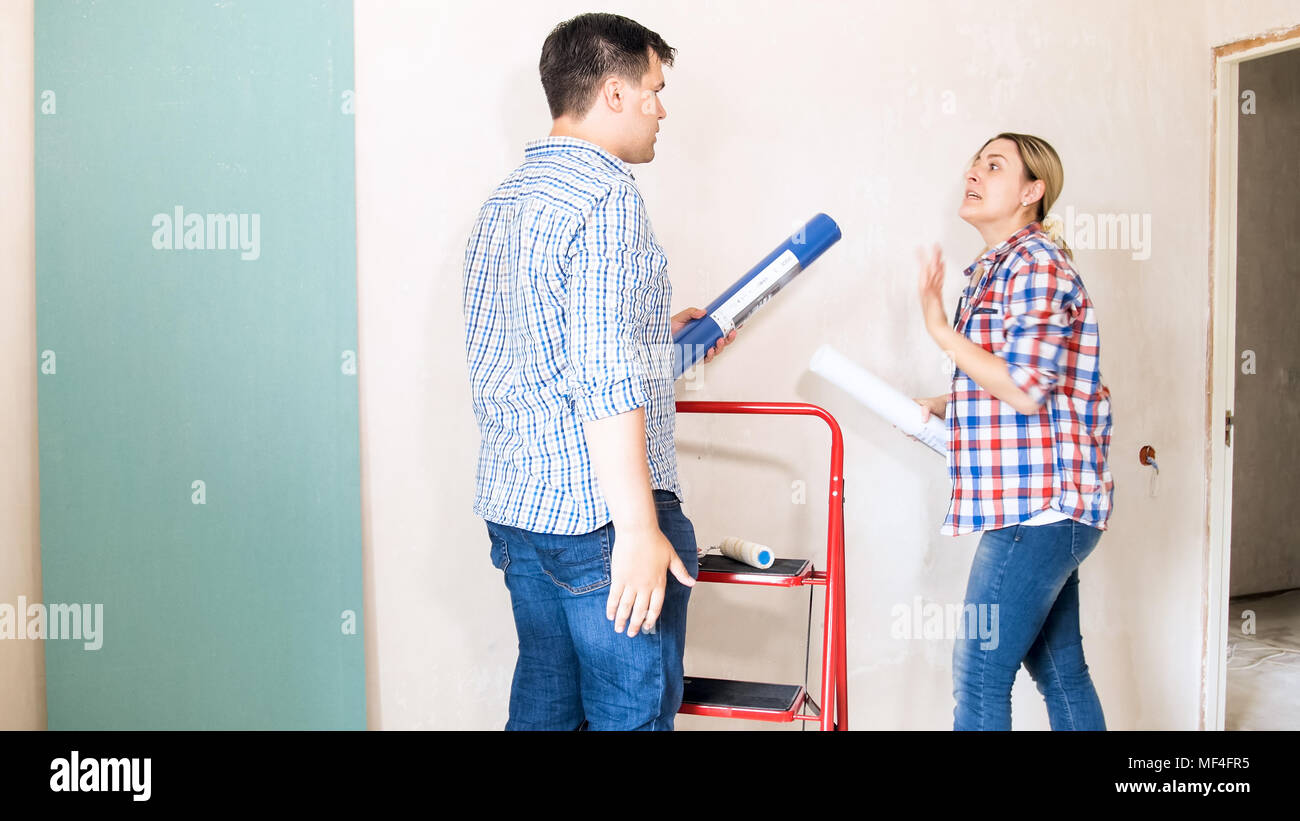 Young couple having conflict because of new wallpapers for renovation ...