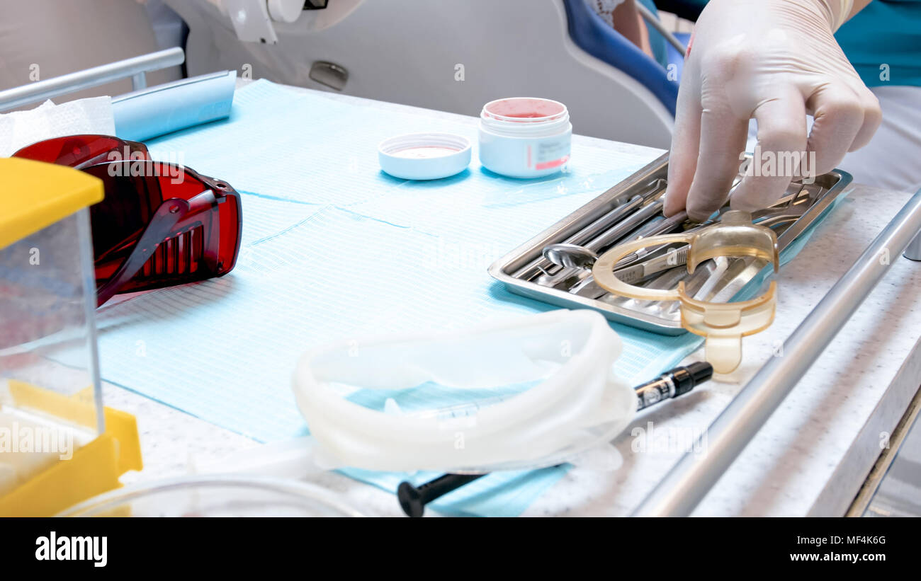 Closeup image of doctors hand taking special metal instruments from ...