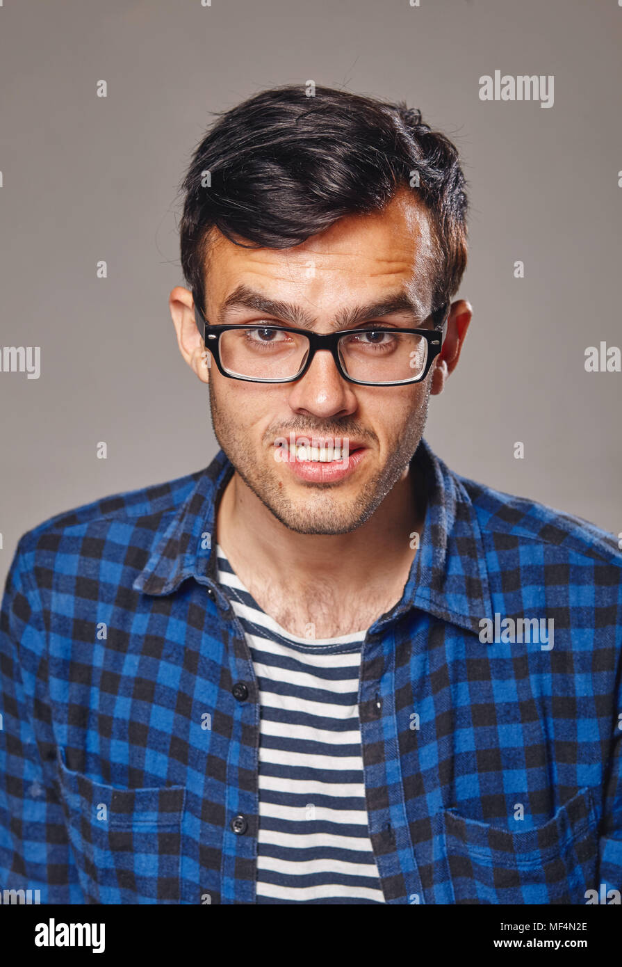 young man standing over grey background Stock Photo - Alamy