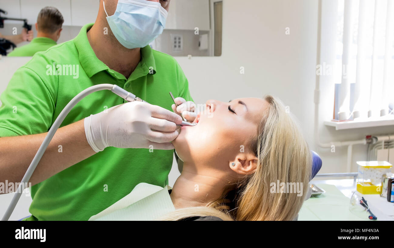 Closeup image of dentist using special dental drill to remove caries ...
