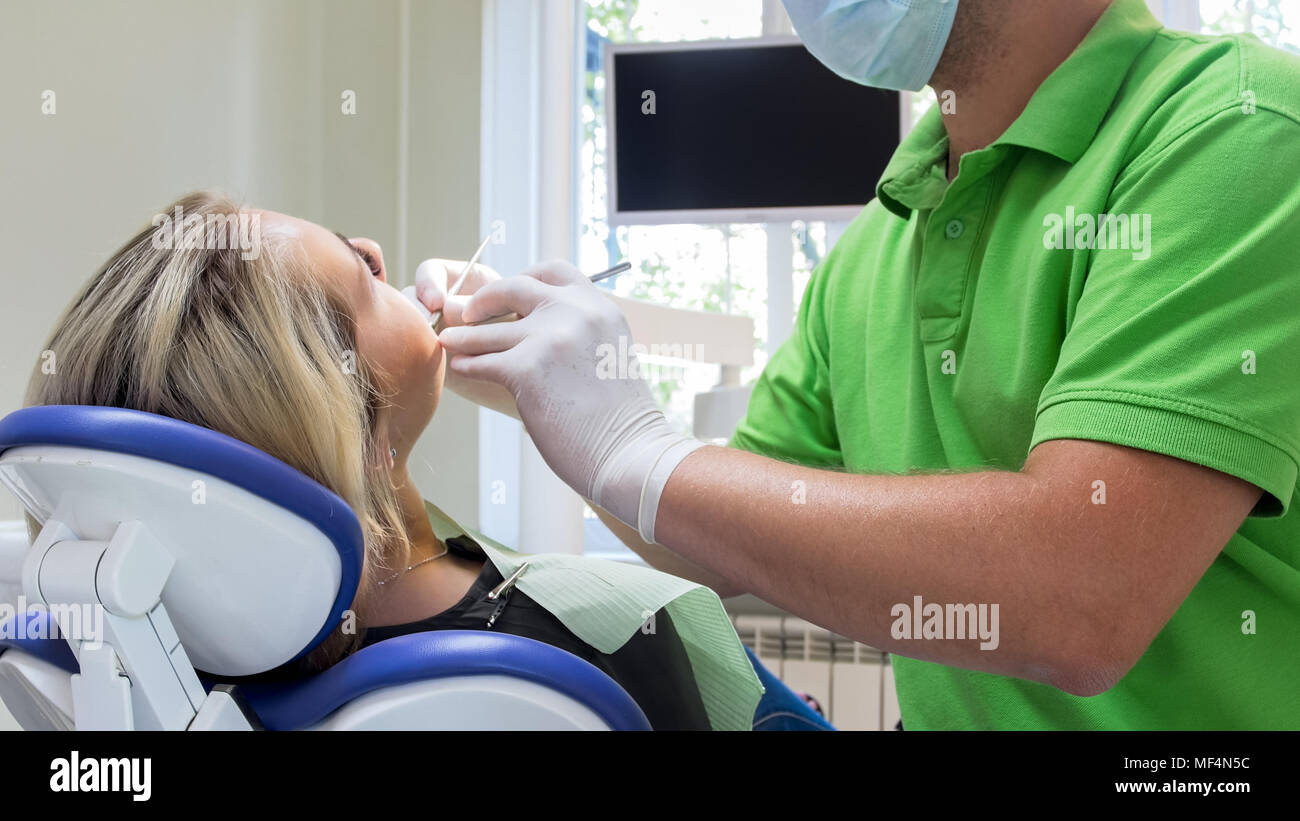 Closeup image of male dentist inspecting patient oral cavity Stock ...