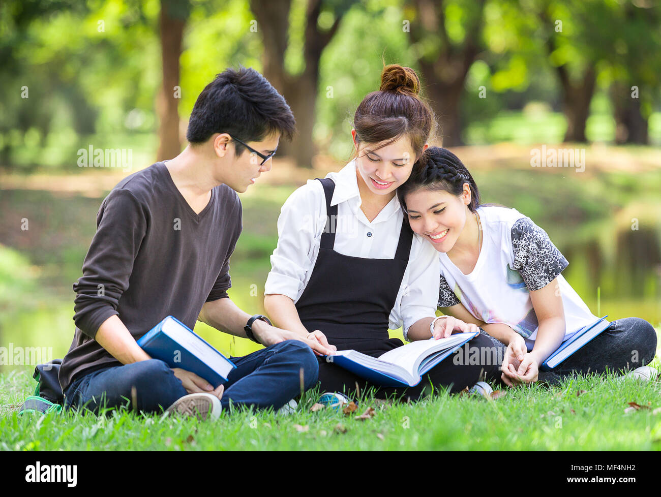 group of young student, university, read a book in park with happy ...