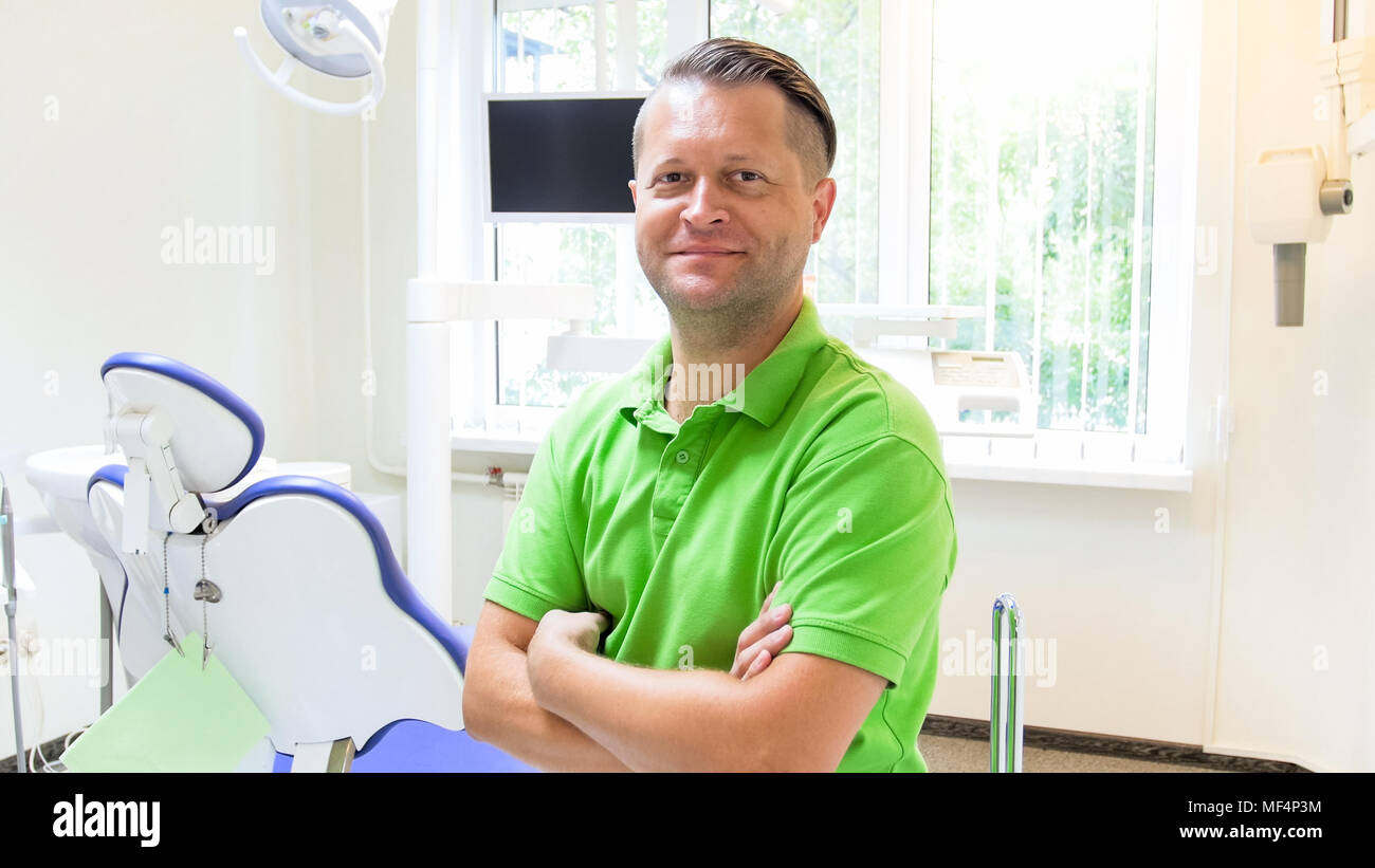 Portrat of handsome male dentist posing in dental clinic Stock Photo ...