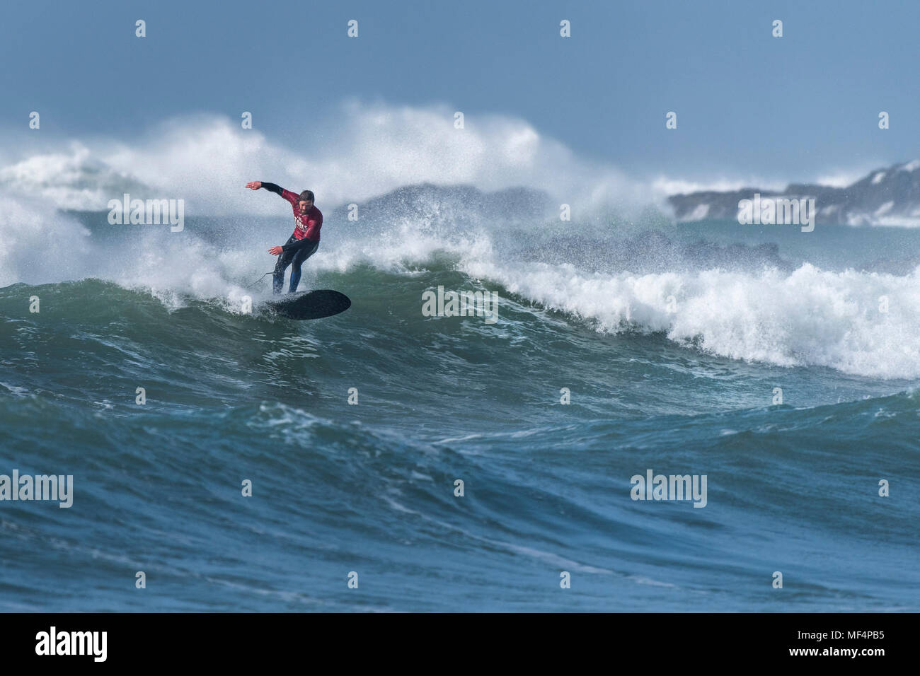 A surfer competing in a longboard surfing competition at Fistral Beach ...