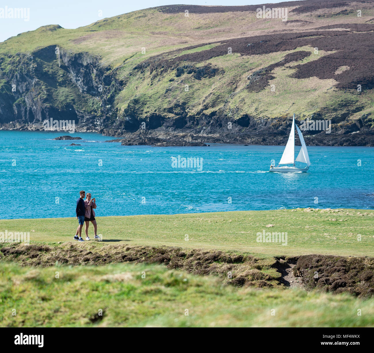 Young couple at the Sound coastal path, sailing boat going pass Stock ...