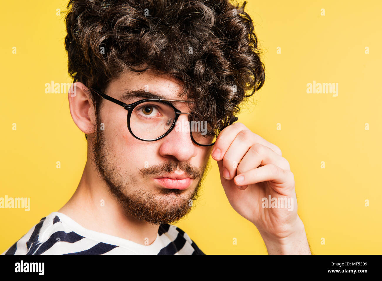 Studio portrait of a young man a yellow background Stock Photo - Alamy