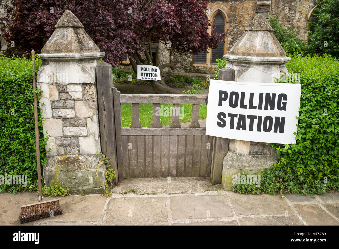 British election polling station sign hanging on post next to a gate ...