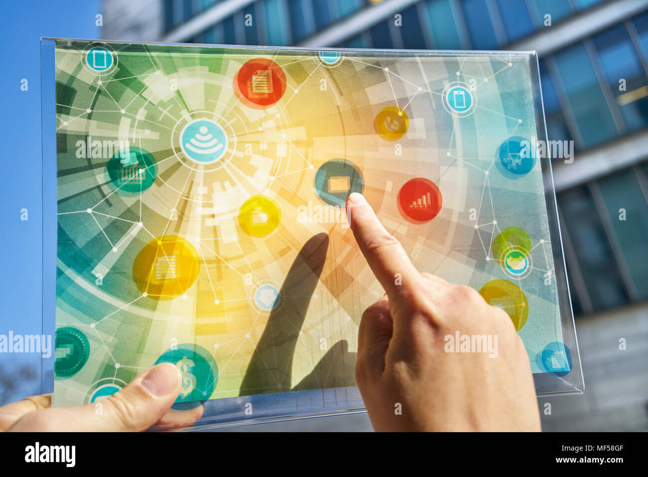 Hand holding futuristic device with digital icons Stock Photo - Alamy