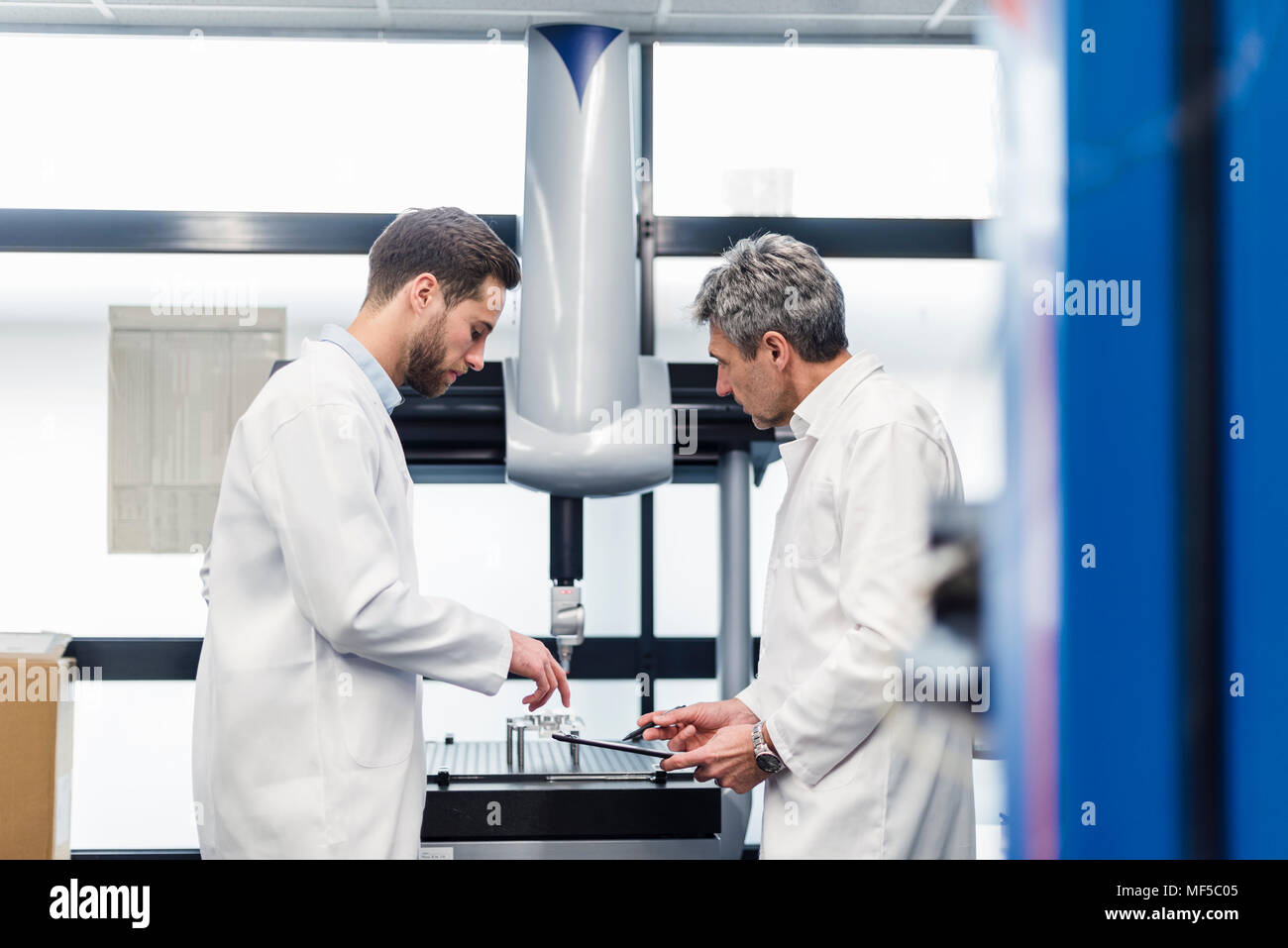 Engineers checking a machine Stock Photo - Alamy