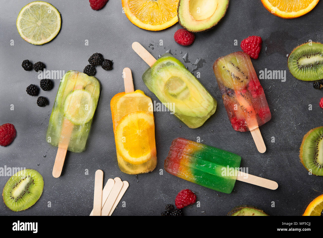 Various fruit popsicles and fruits on grey background Stock Photo - Alamy
