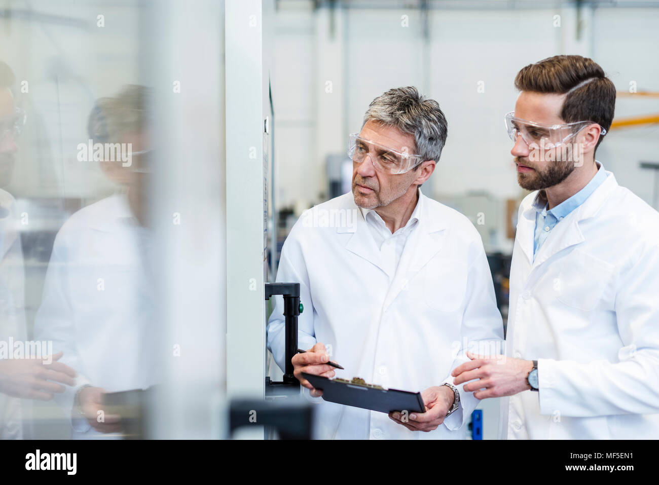 Engineers checking a machine Stock Photo - Alamy