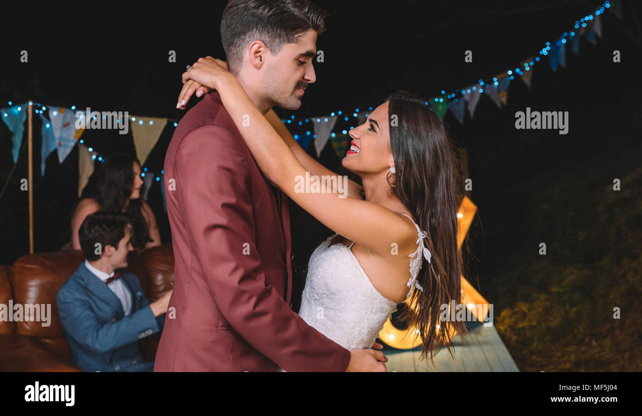 Romantic wedding couple embracing on a night field party with their ...