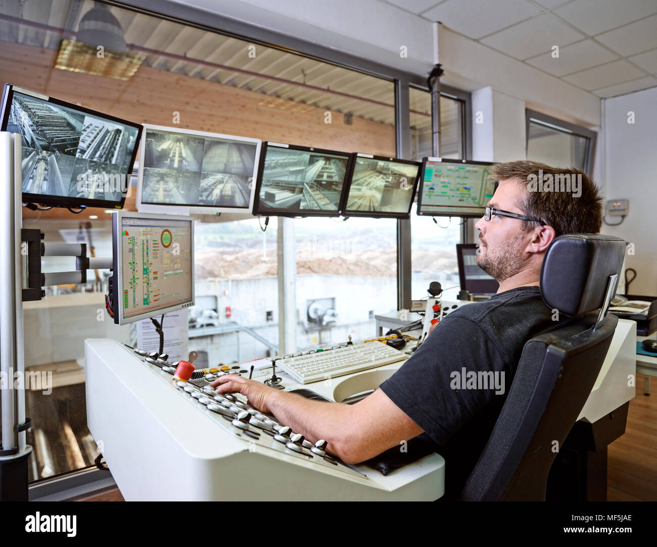Worker controlling production with monitors Stock Photo - Alamy
