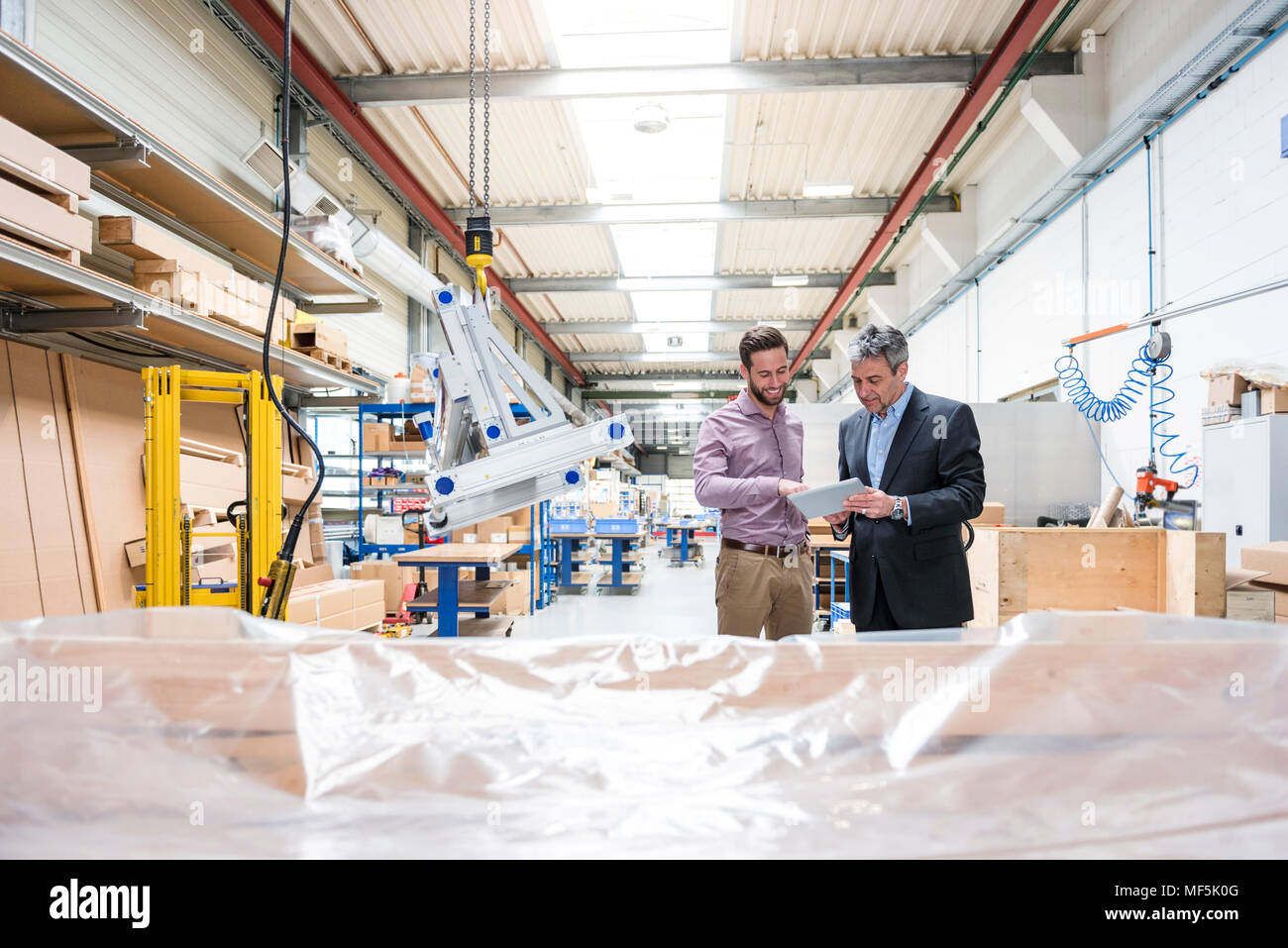 Businessmen during meeting in production hall Stock Photo - Alamy
