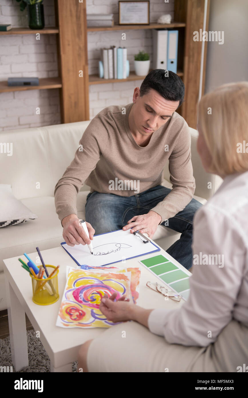 Earnest pensive man drawing his fear Stock Photo - Alamy