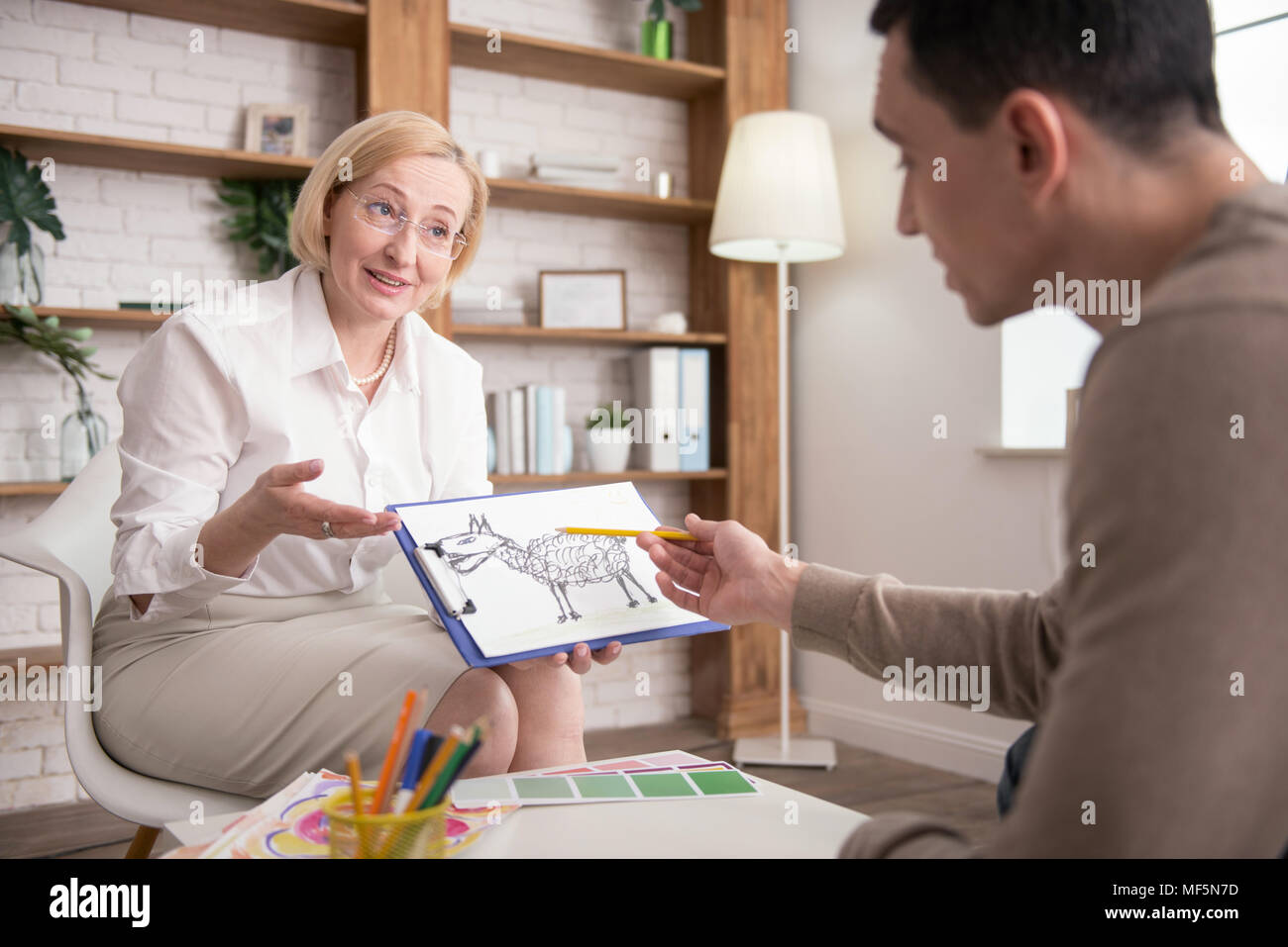 Optimistic mature psychologist deciphering meaning Stock Photo - Alamy