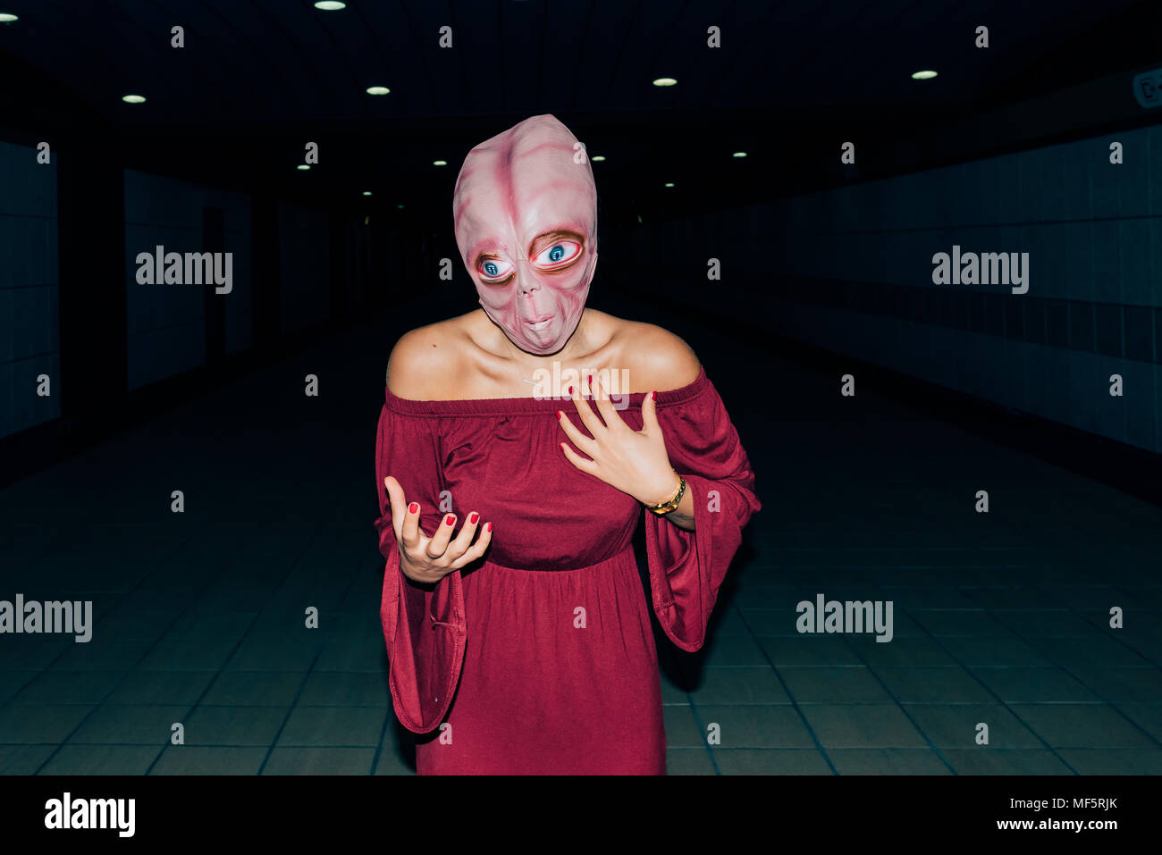 young woman indoor wearing alien mask - strange, carnival, halloween ...