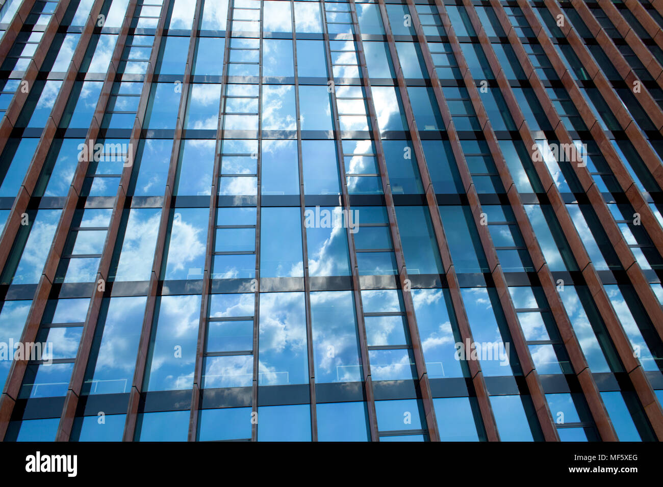 A large glass building with a reflection of the blue sky. Abstract blue ...