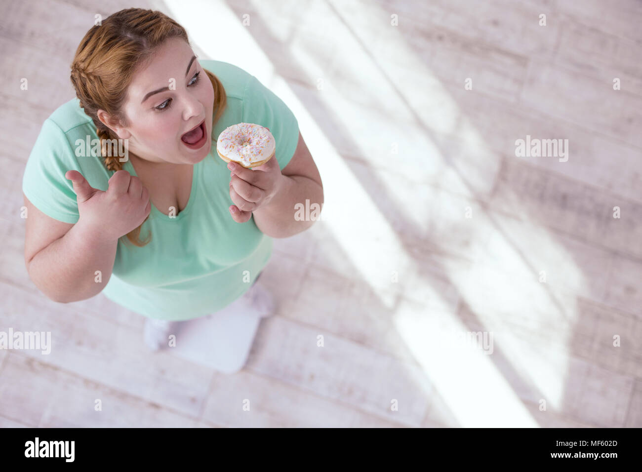 Obese young woman eating sweets Stock Photo - Alamy