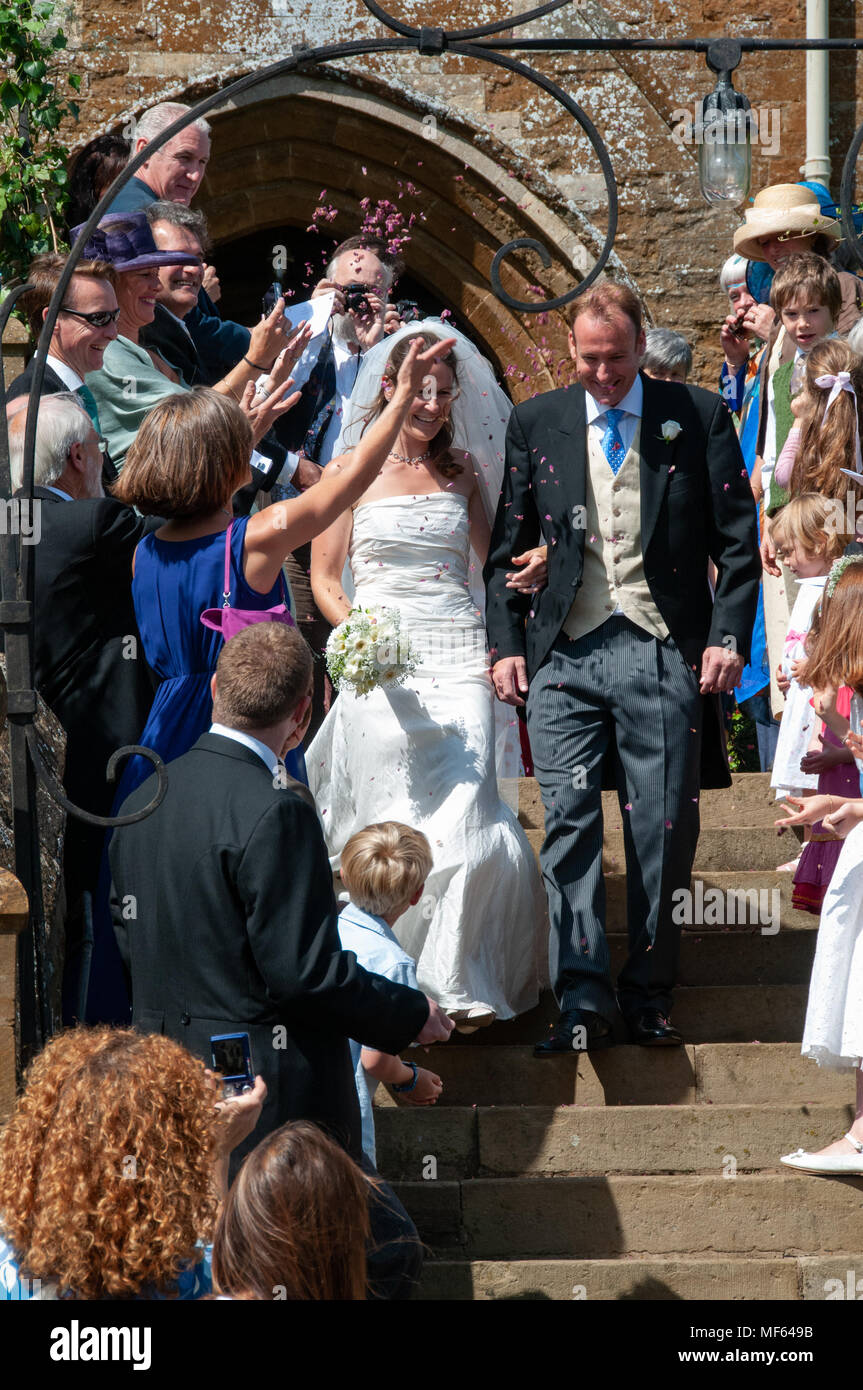 Confetti throwing over traditional wedding couple leaving church on a ...