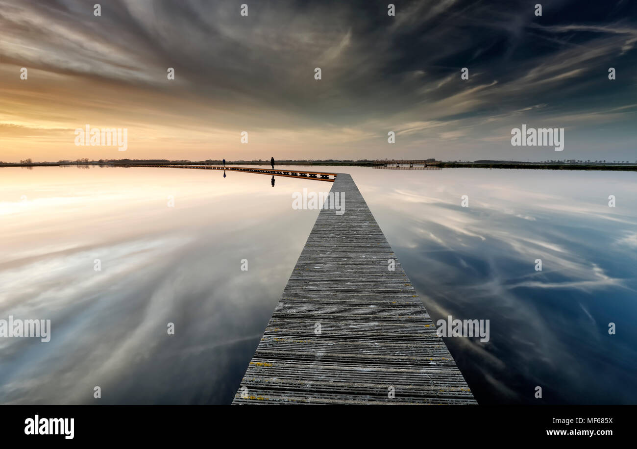 wooden path on water on big lake before sunset Stock Photo - Alamy